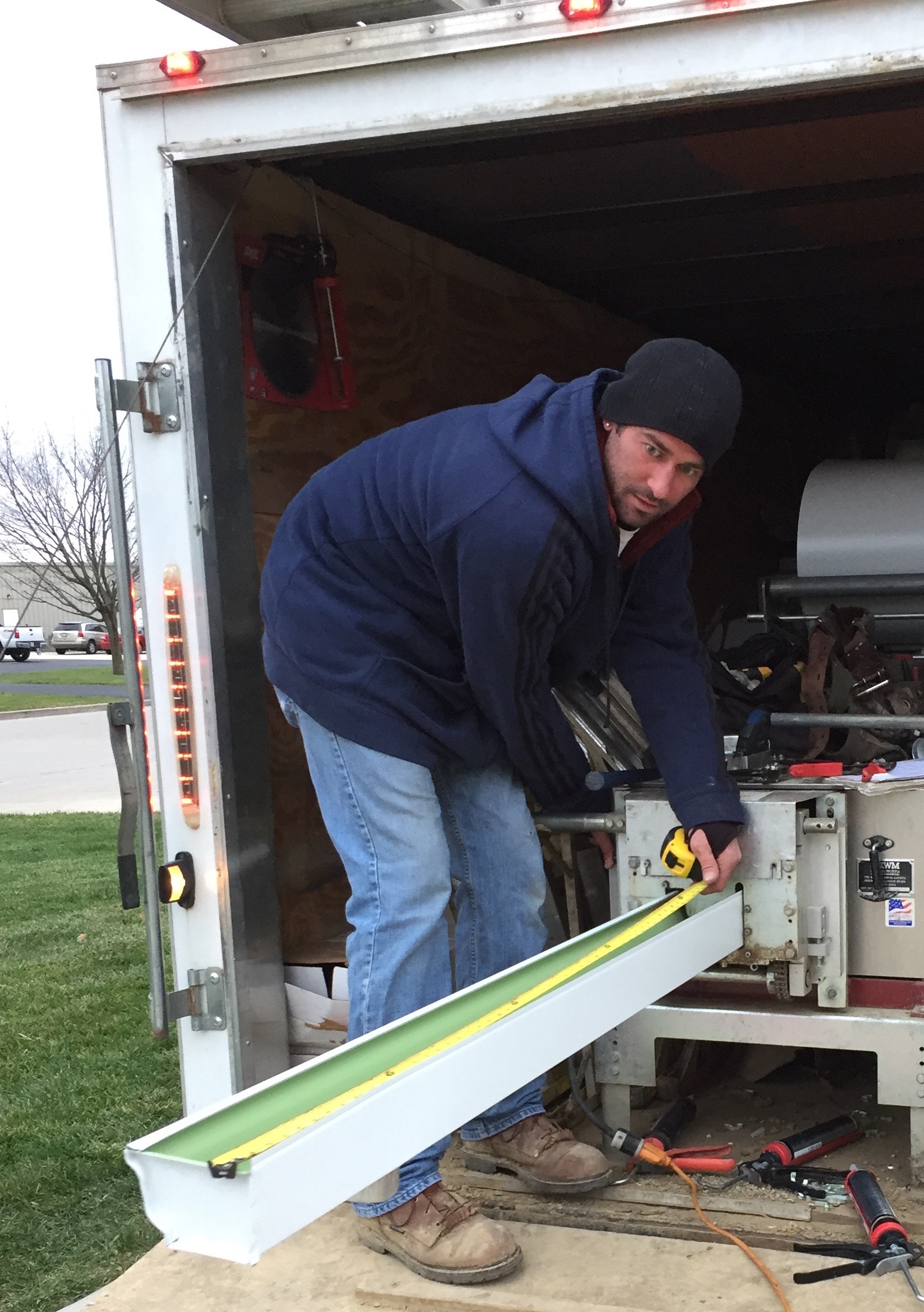 foreman-brad-smith-measure-the-length-of-a-seamless-gutter-in ...